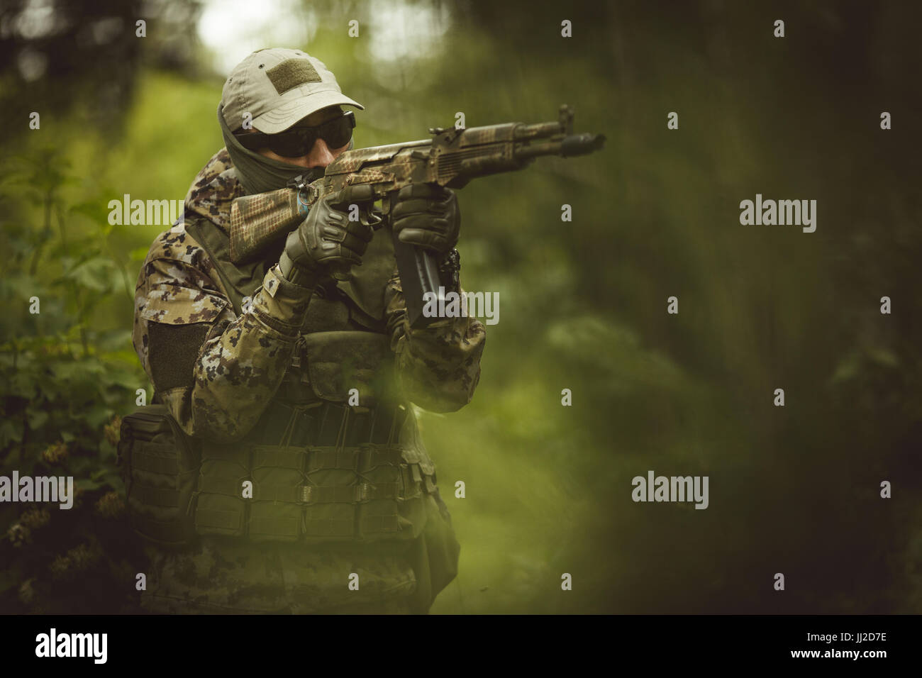 Soldier in camouflage among trees Stock Photo - Alamy