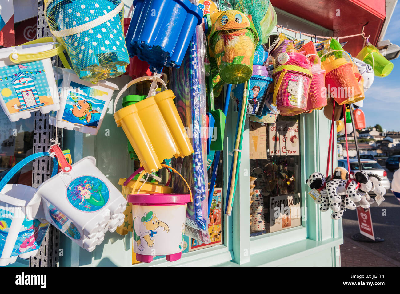 Buckets, spades and fishing nets hanging up for sale at a seaside shop ...
