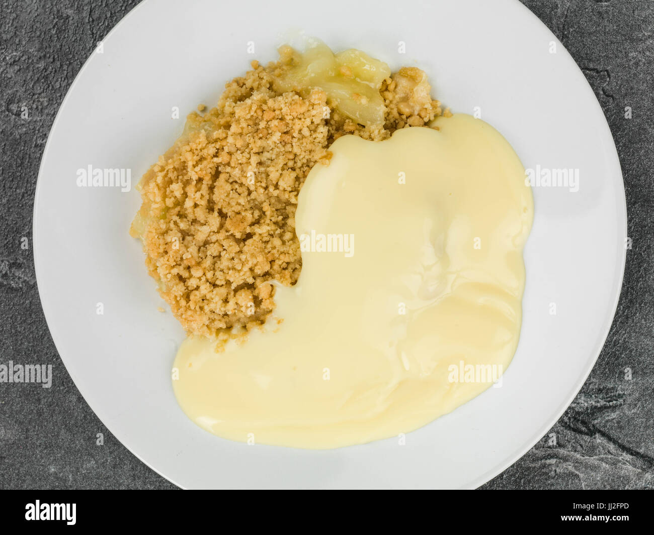 Apple Crumble Dessert Served With Hot Custard Against a Black Slate ...