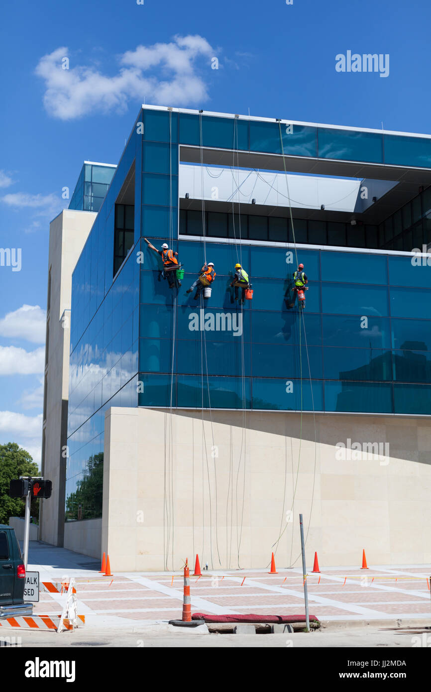 Four window washers on the outside of a building Stock Photo - Alamy