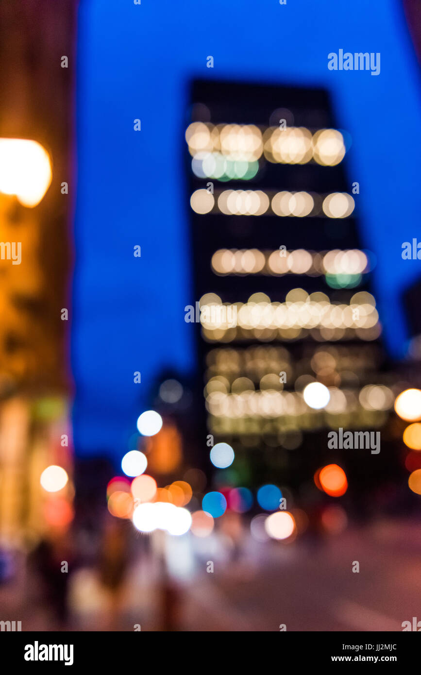 Bokeh lights background of modern skyscraper building at night in ...