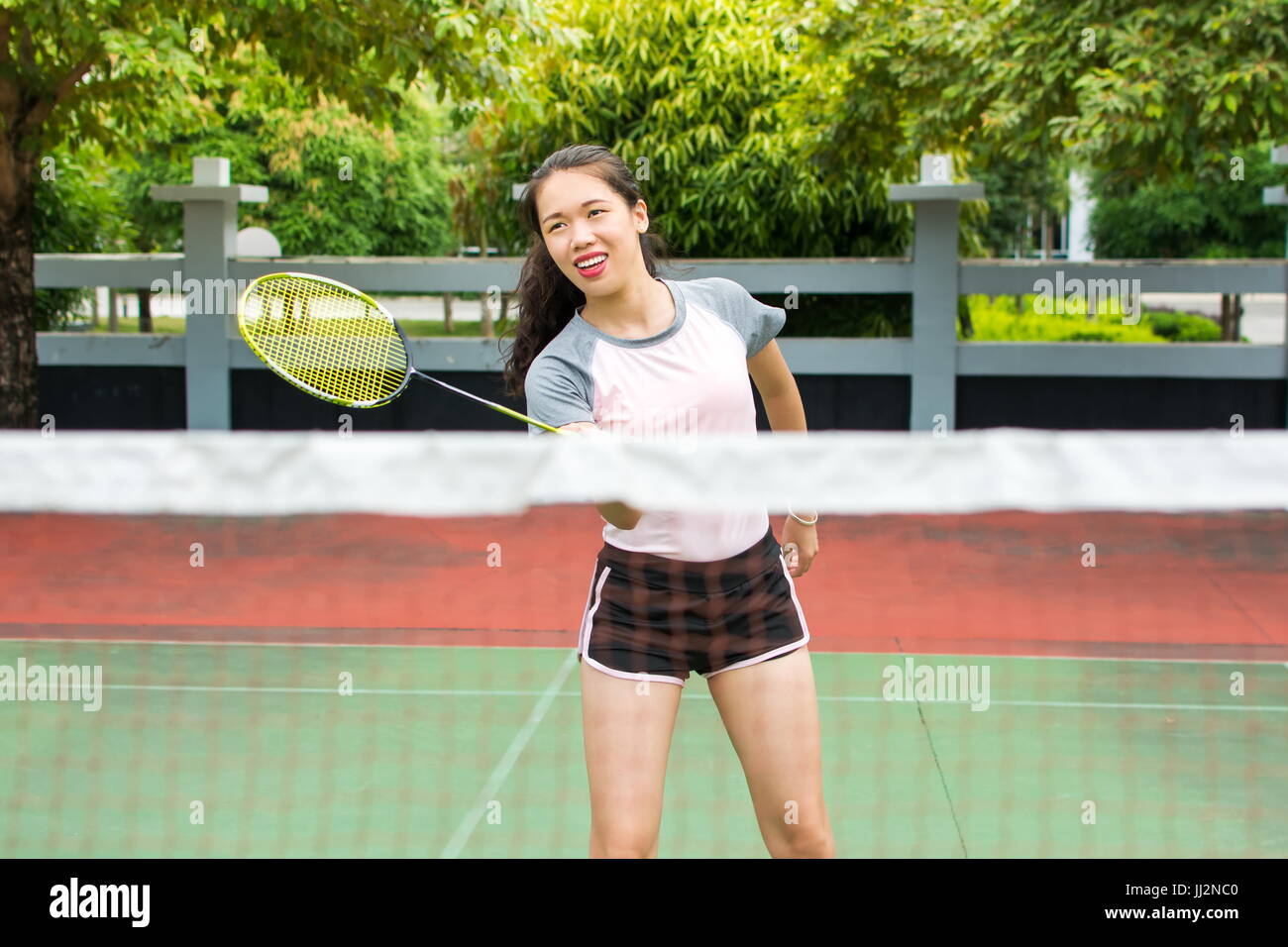 Asian girl playing badminton on the outdoors court Stock Photo - Alamy