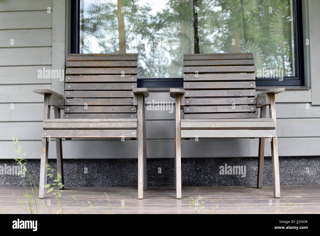 Two chairs on patio. Window with reflection on background Stock Photo ...