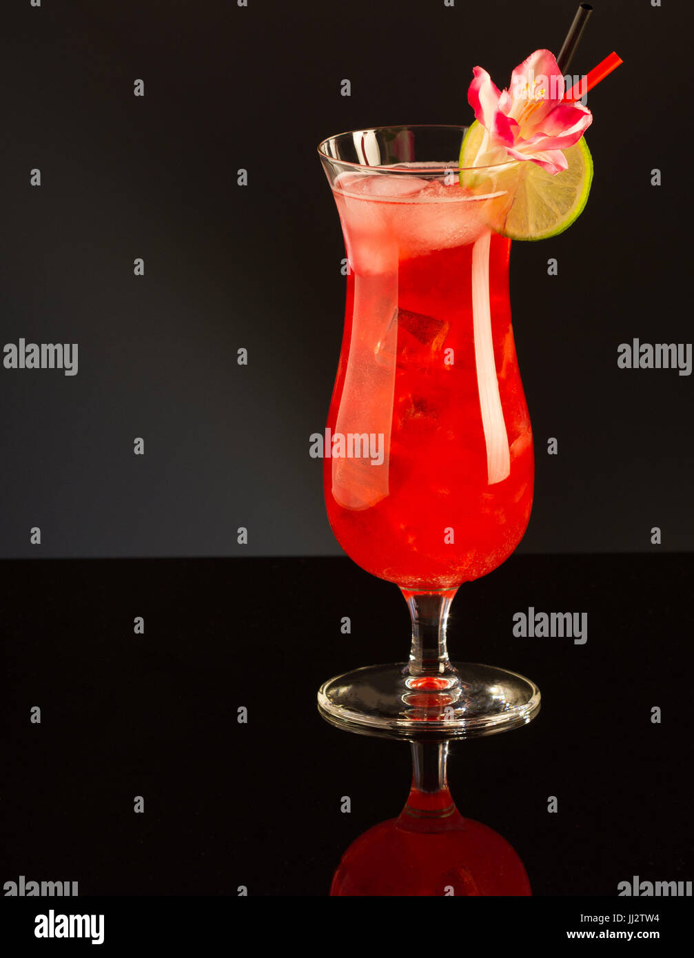 Tropical cocktail garnished with lime slice Stock Photo - Alamy