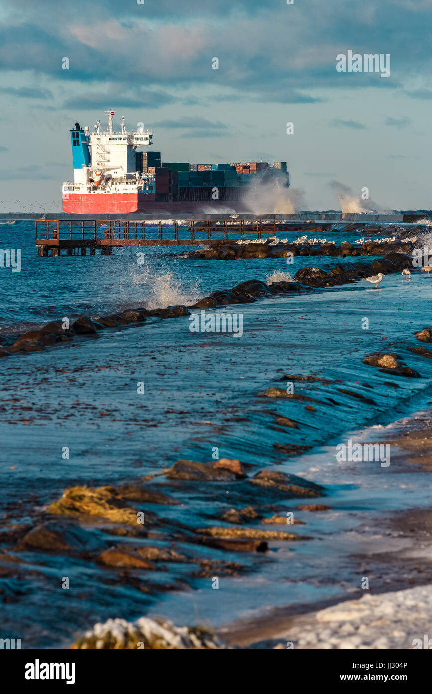 Full red container ship moving in stormy weather Stock Photo - Alamy