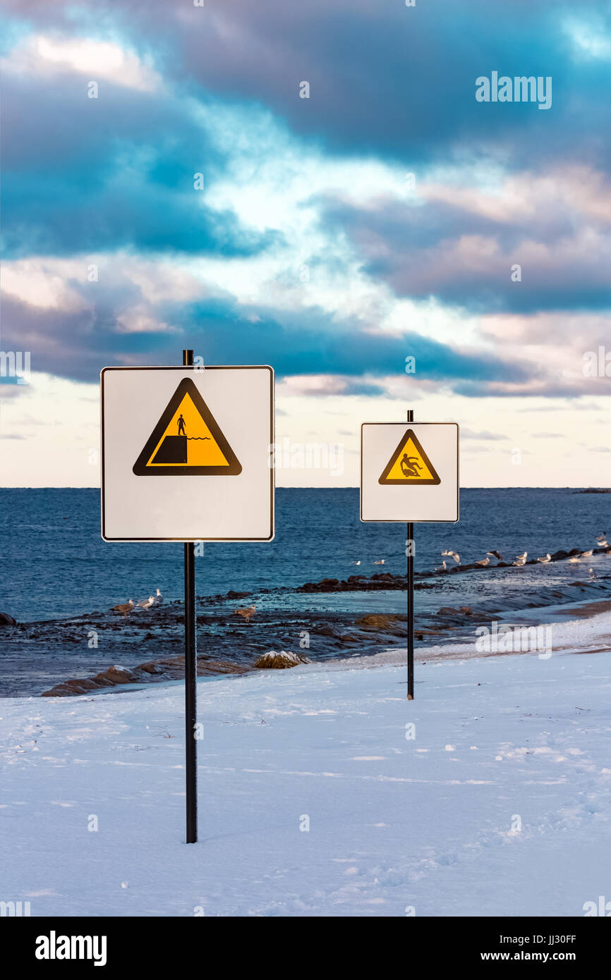 Two yellow warning signs on the winter beach Stock Photo - Alamy