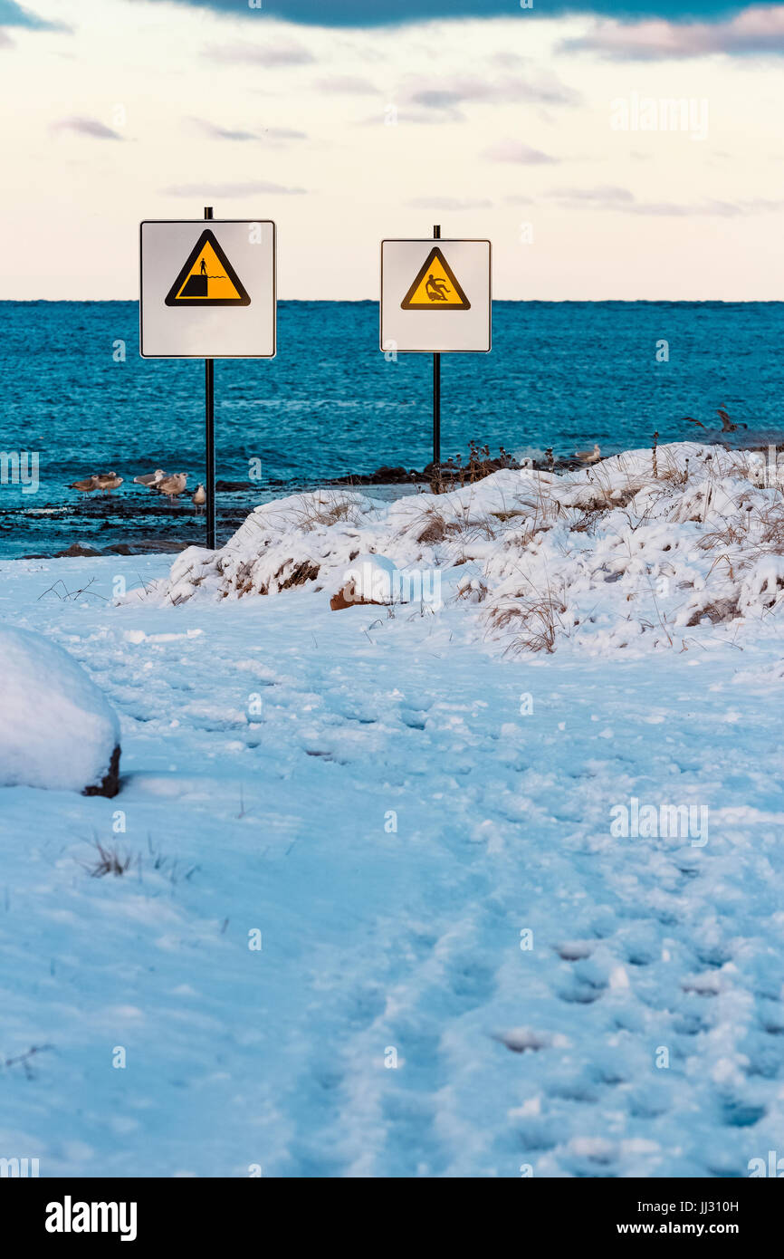 Two yellow warning signs on the winter beach Stock Photo - Alamy