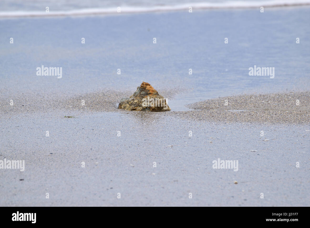 A little rock on the beach shore Stock Photo - Alamy