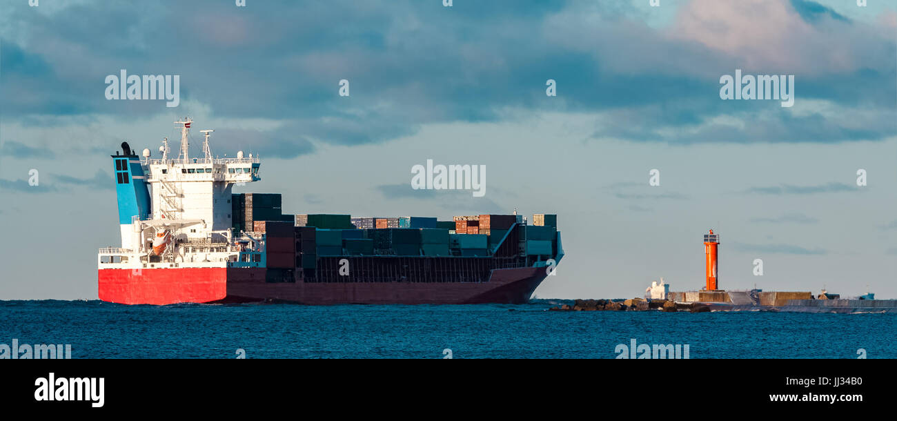 Full red container ship moving in still water Stock Photo - Alamy
