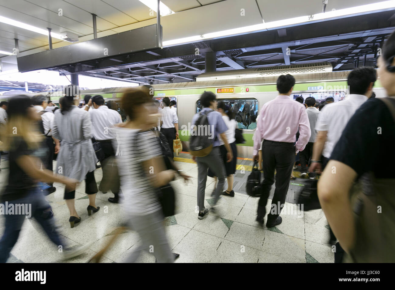 Commuters try to board the train during the peak-hour at Shibuya ...