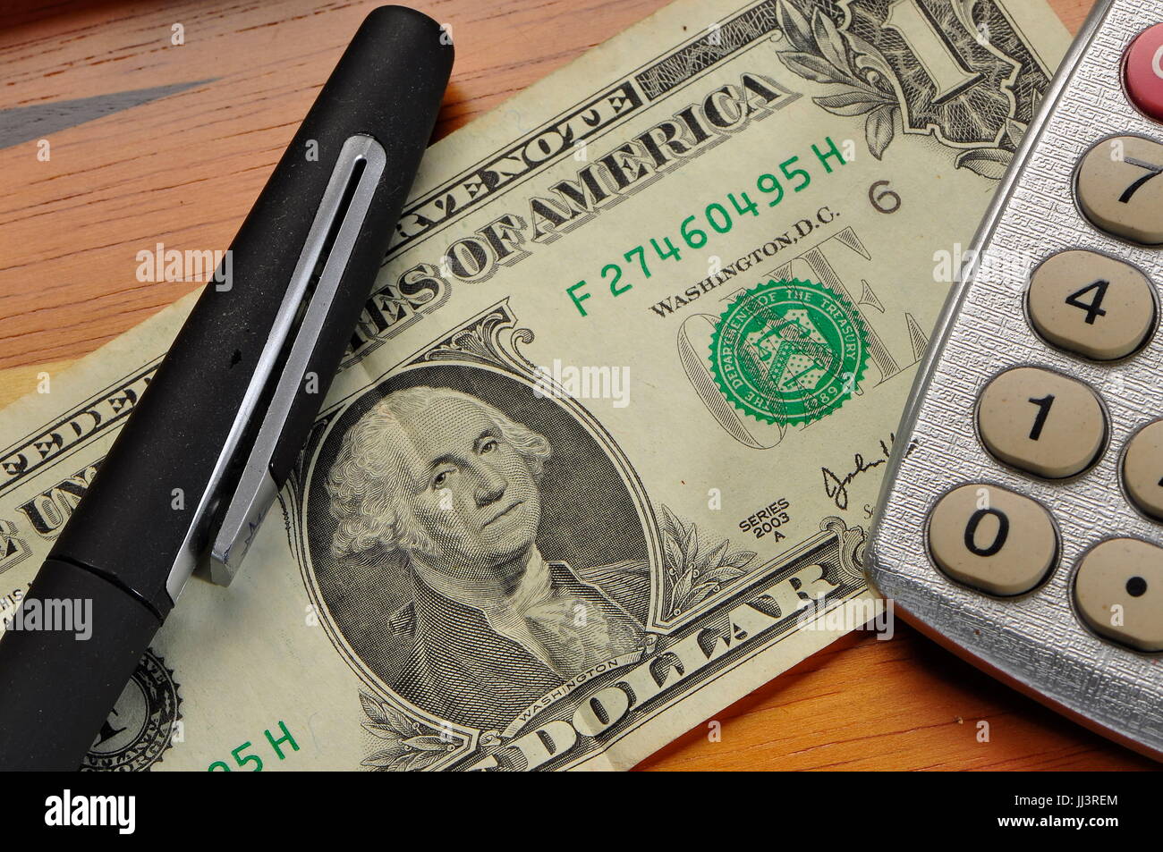 Concept, one dollar note on the table along with calculator and pen ...
