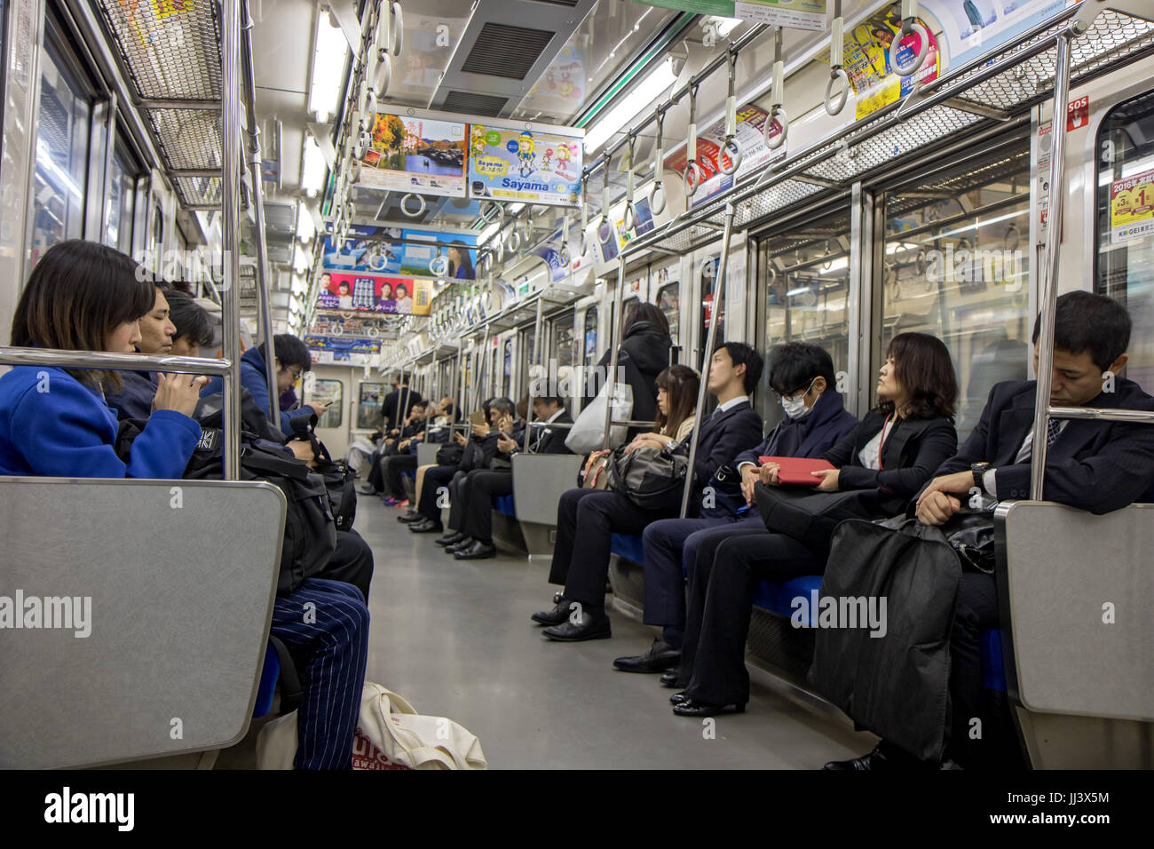 TOKYO, JAPAN - NOVEMBER 22, 2016, passengers commuting in subway train ...