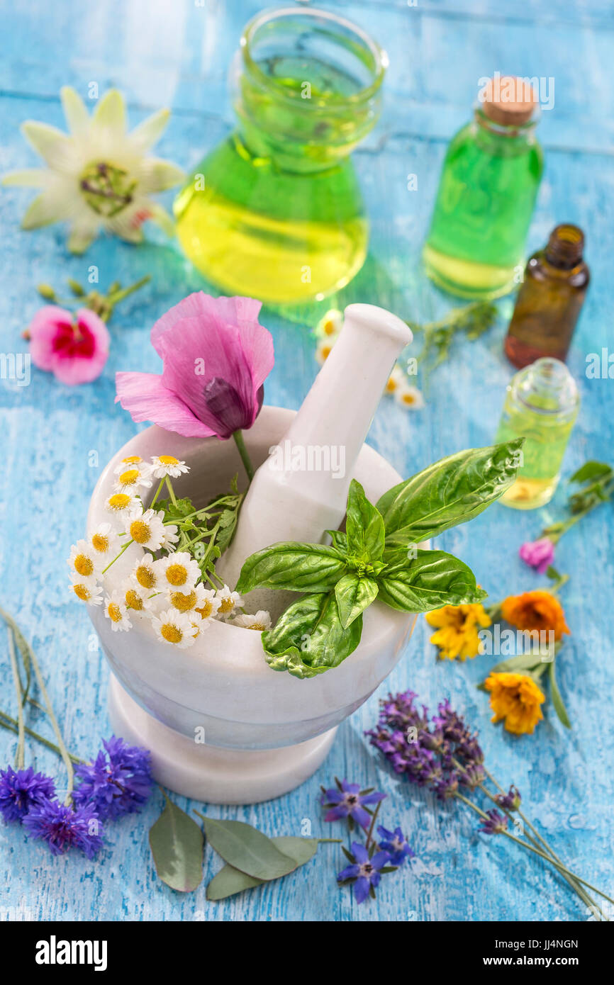 essential oils for aromatherapy treatment with fresh herbs in mortar ...
