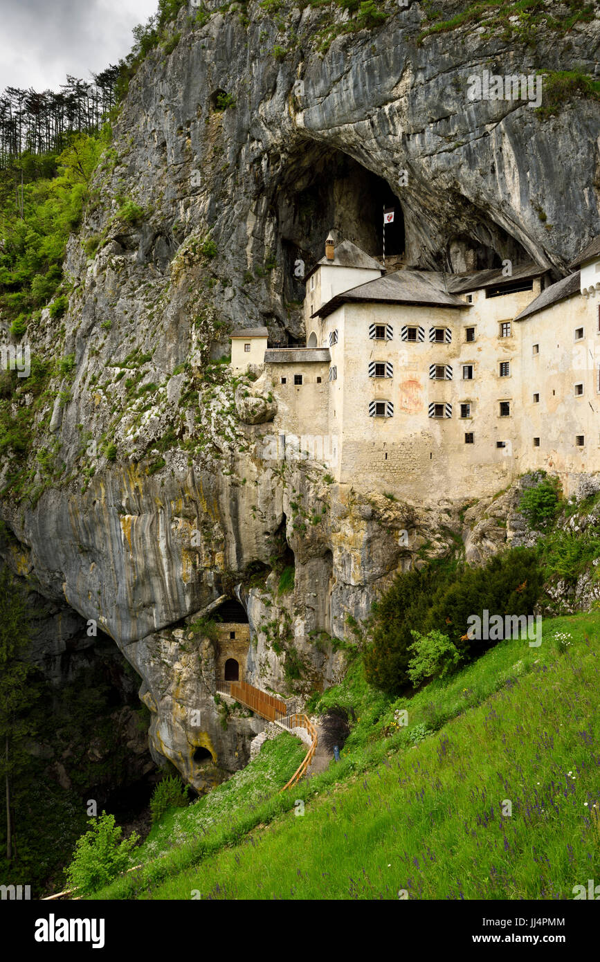 Grass hillside and cliff cave entrances at Predjama Castle 1570 ...