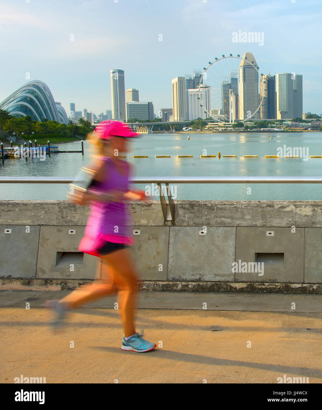 Woman jogging at sunset in Singapore bay. Motion blur Stock Photo - Alamy