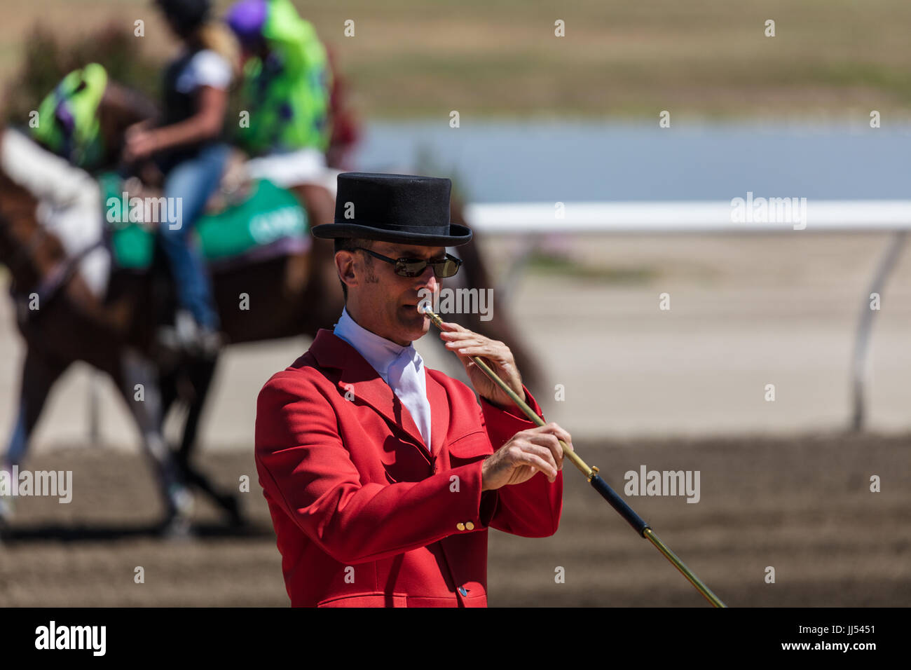 Bugler in top hat and coat plays Cal to the Post at the horse races in ...