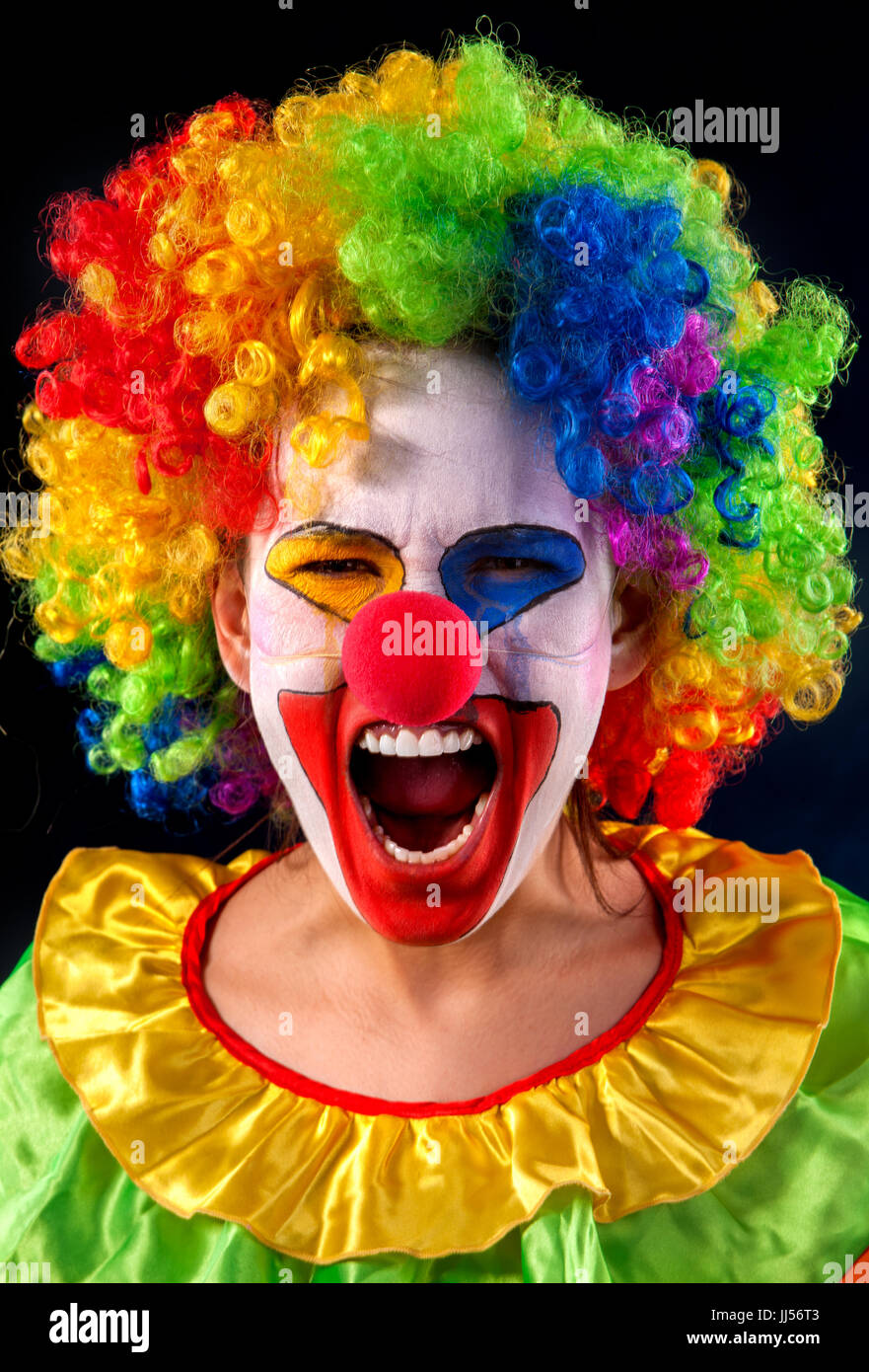Mad clown on black background. Portrait of crazy woman Stock Photo - Alamy