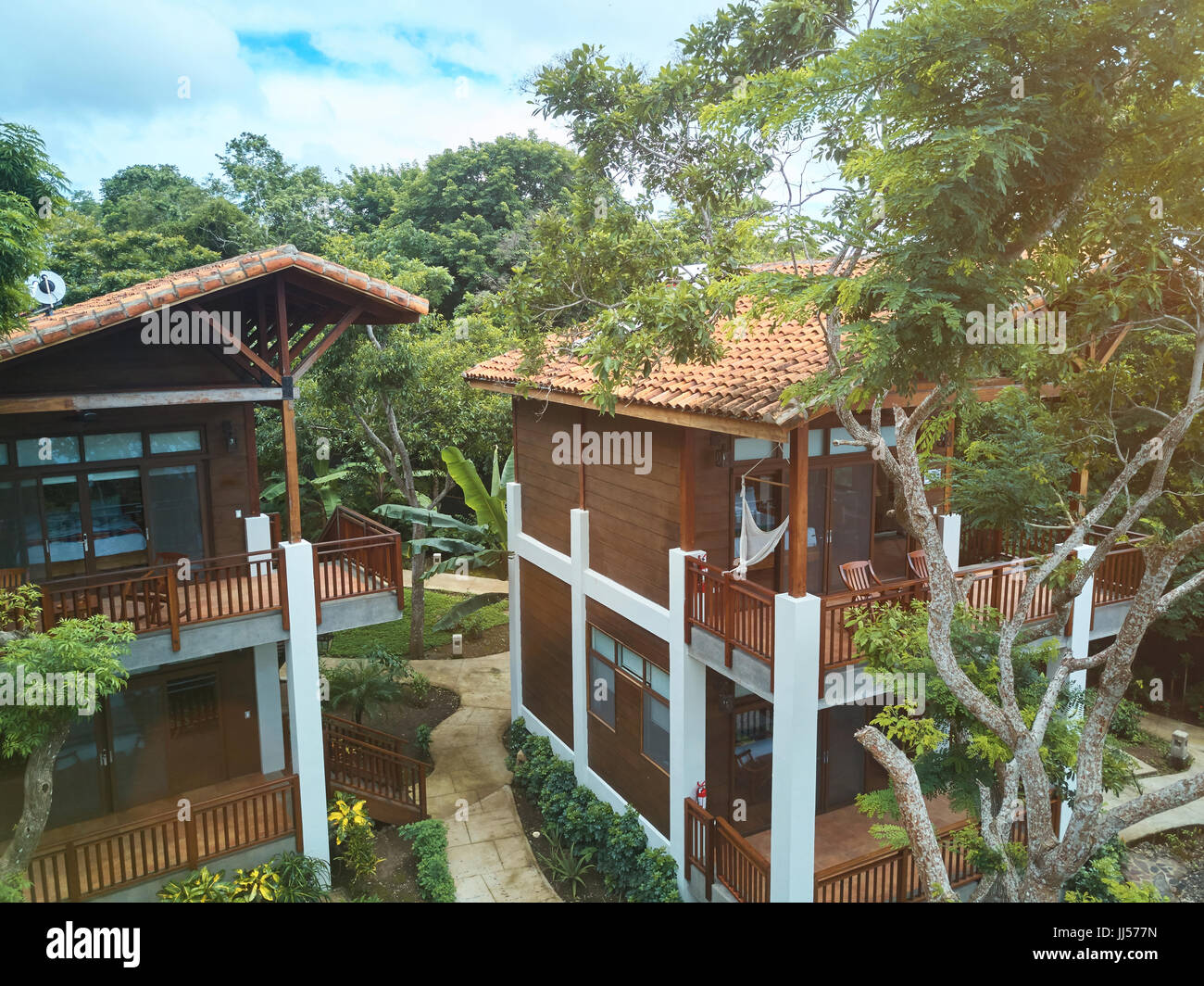 Vacation in nature resort. Aerial view on hotel villas in jungle trees ...