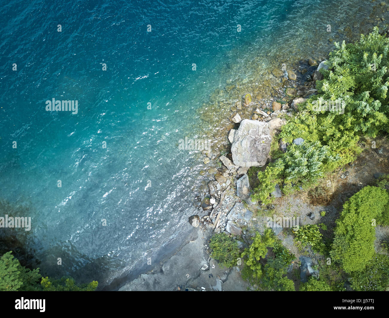 Above view on lagoon shore. Blue water beach with rocks Stock Photo - Alamy