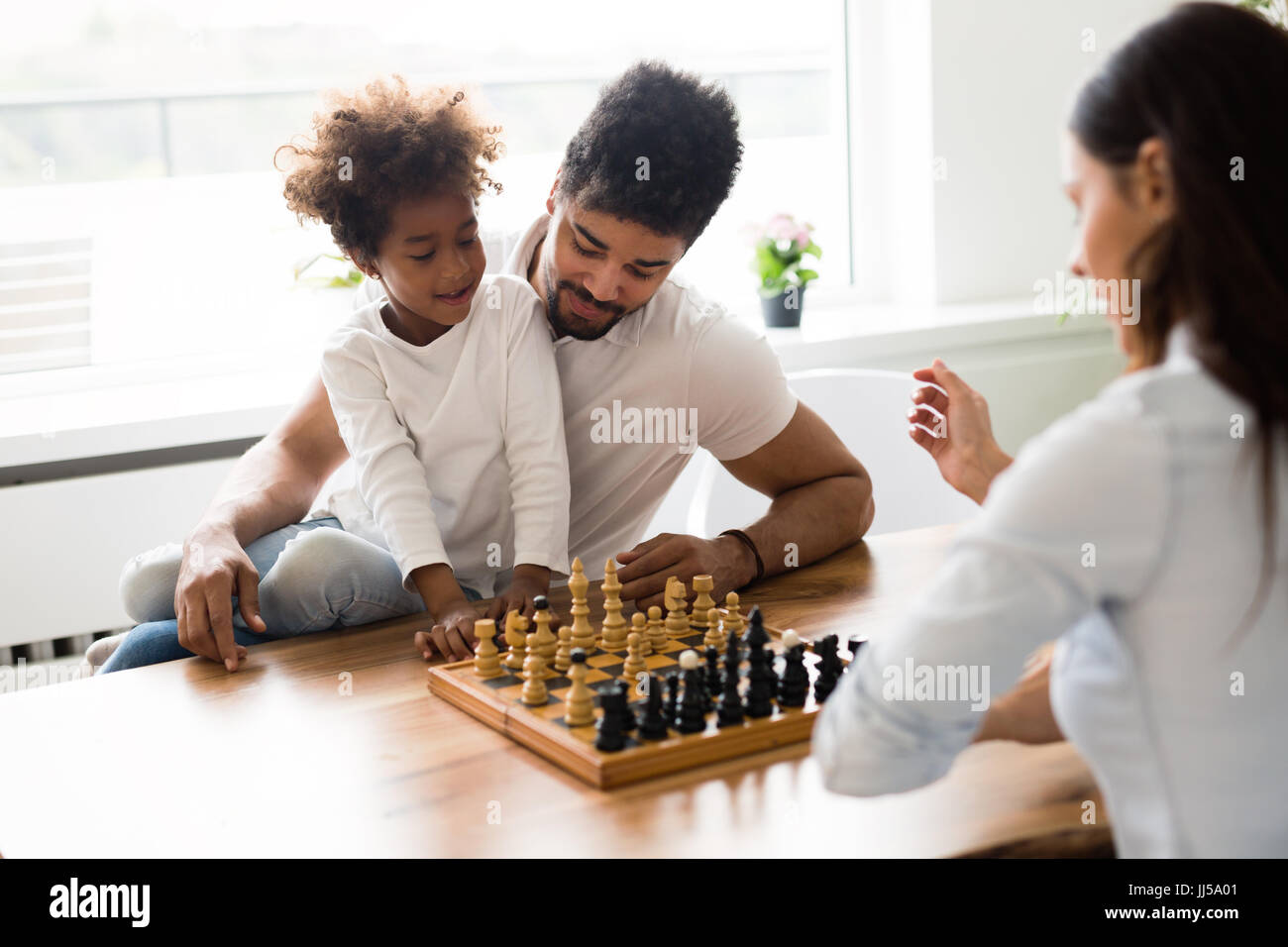 Happy family playing chess together at home Stock Photo - Alamy