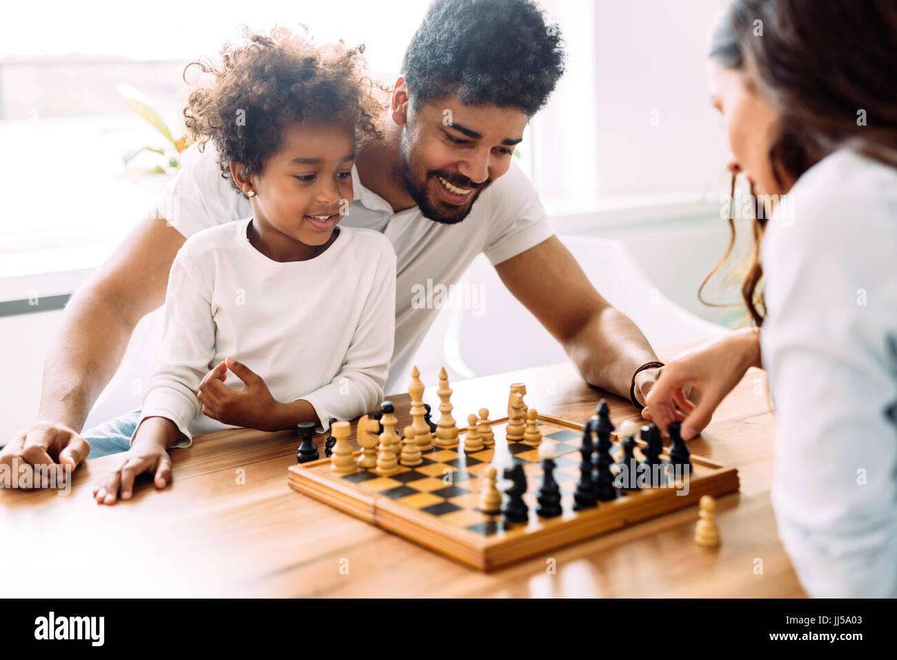 Happy family playing chess together at home Stock Photo - Alamy