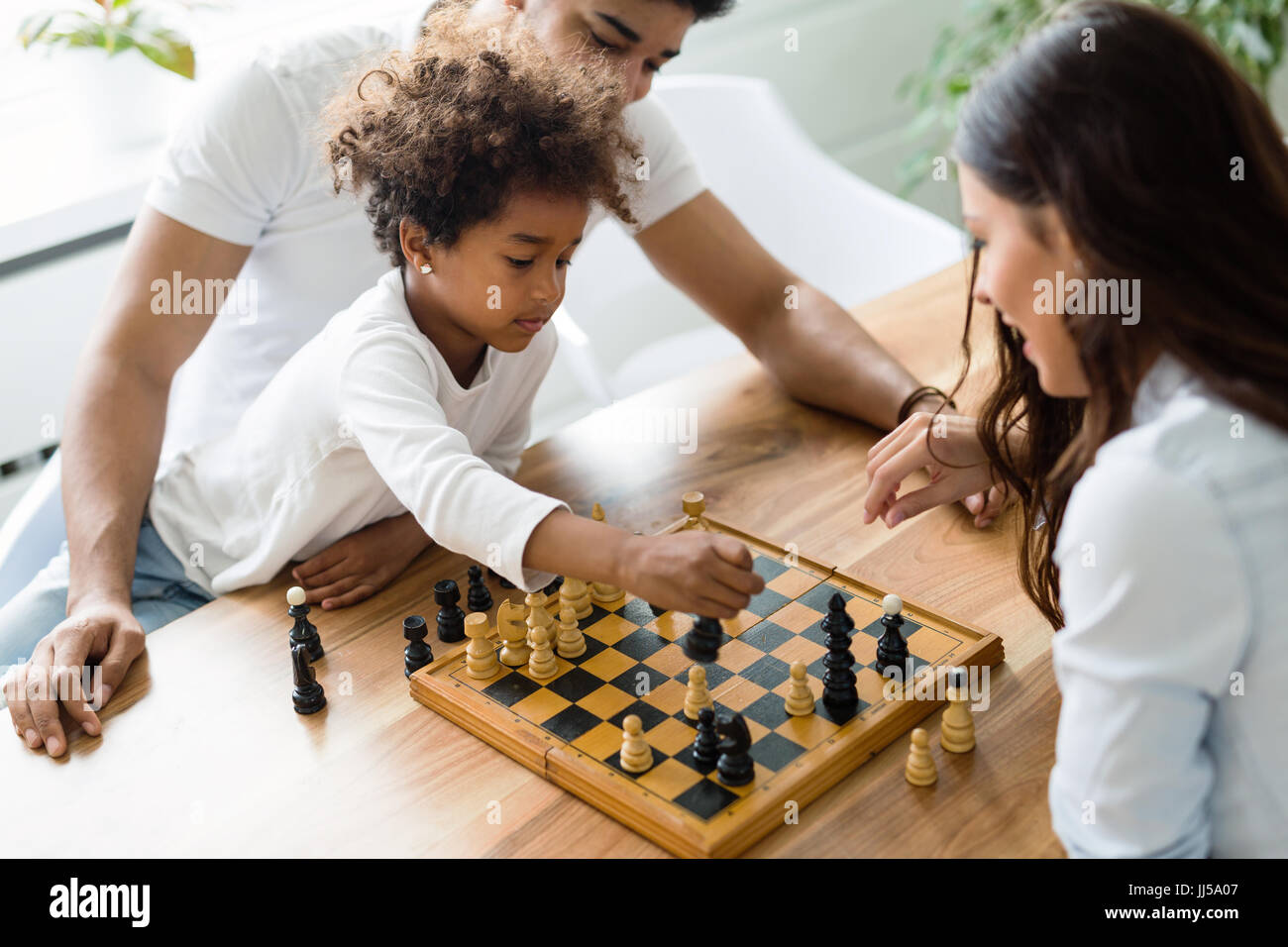 Happy family playing chess together at home Stock Photo - Alamy