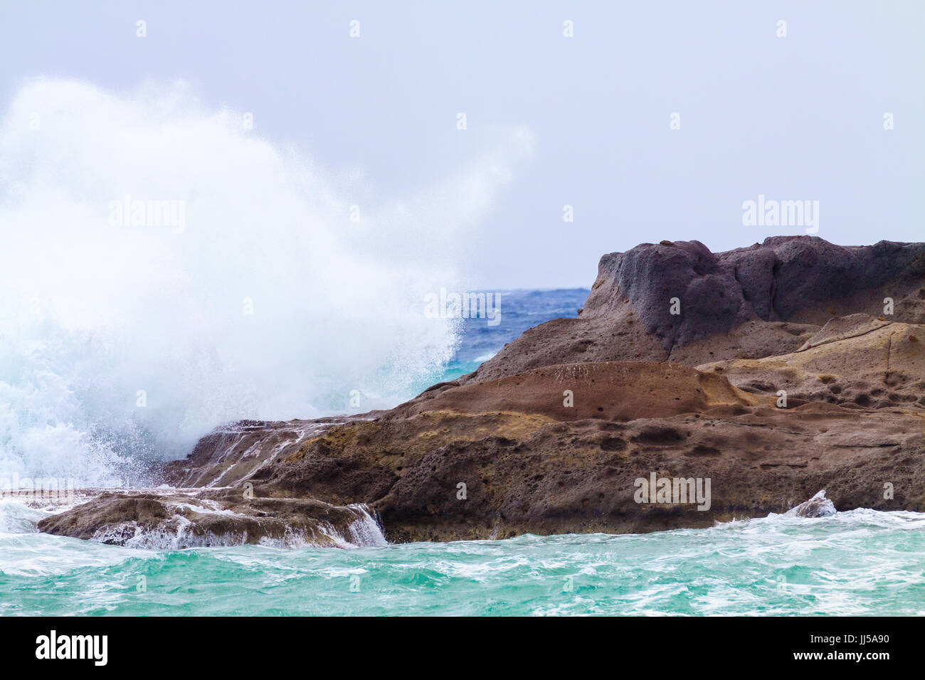 Big waves crashing against of the rocks Stock Photo - Alamy