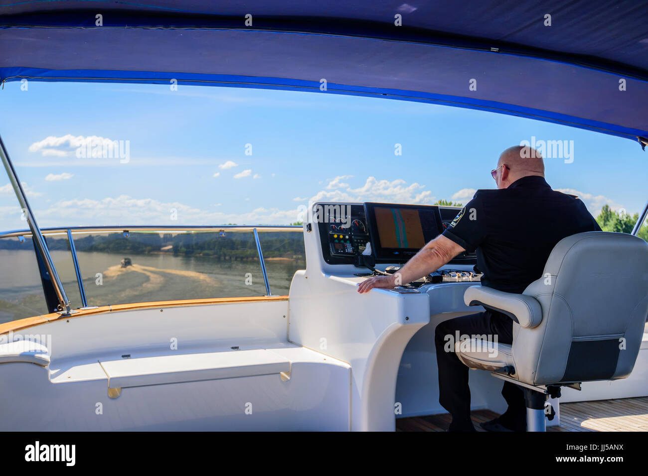 Back view of river boat driver Stock Photo - Alamy