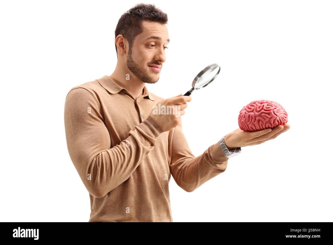 Young guy examining a brain model with a magnifying glass isolated on ...