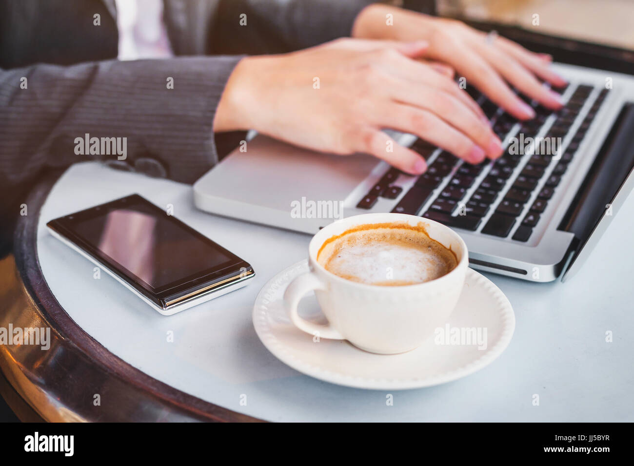 working on computer online, woman checking email on laptop in cafe ...