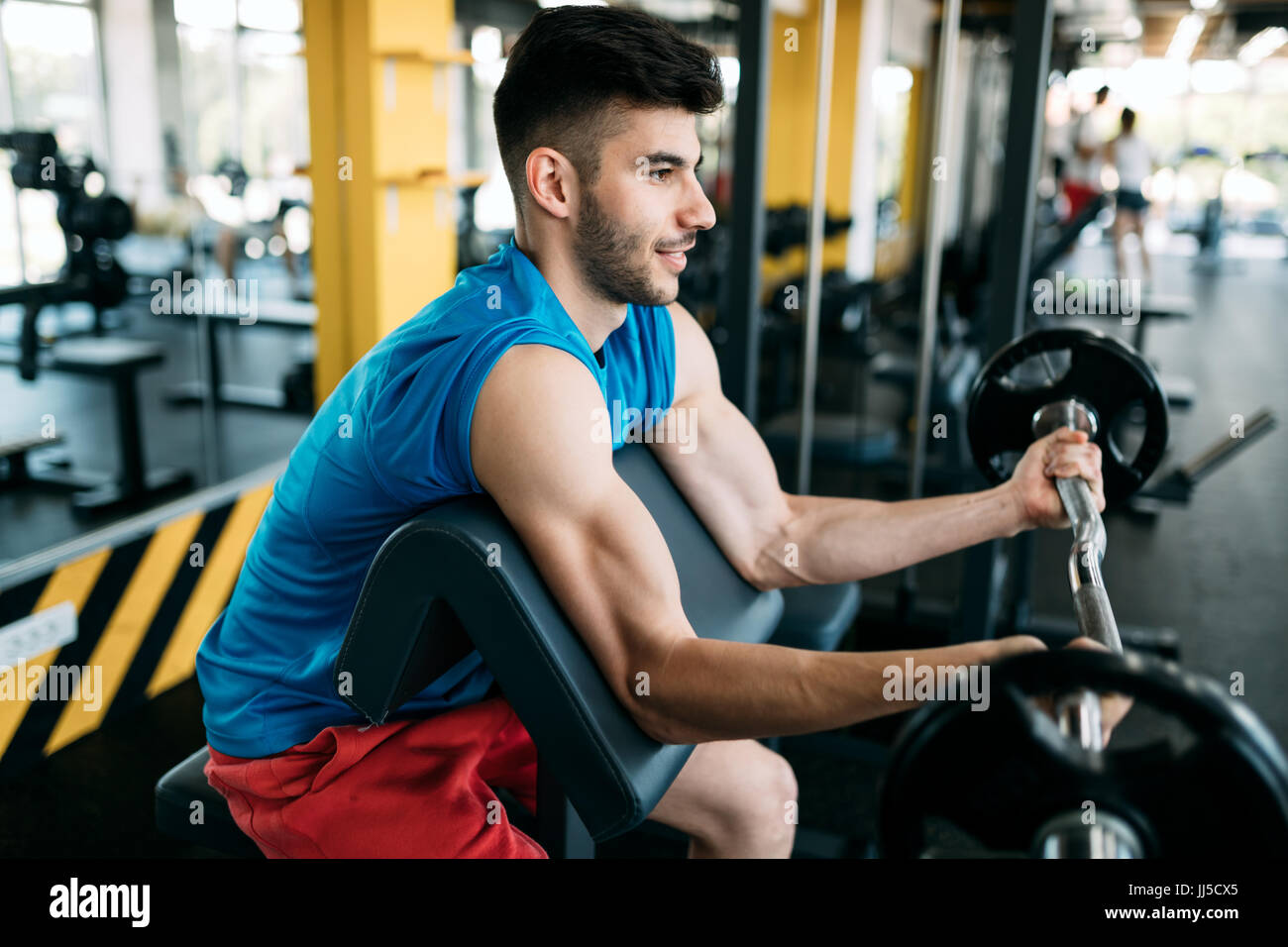 Young attractive man doing exercises in gym Stock Photo - Alamy