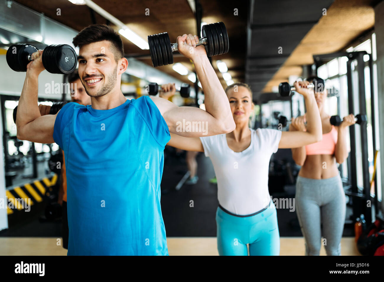 Group of friends exercising together in gym Stock Photo - Alamy