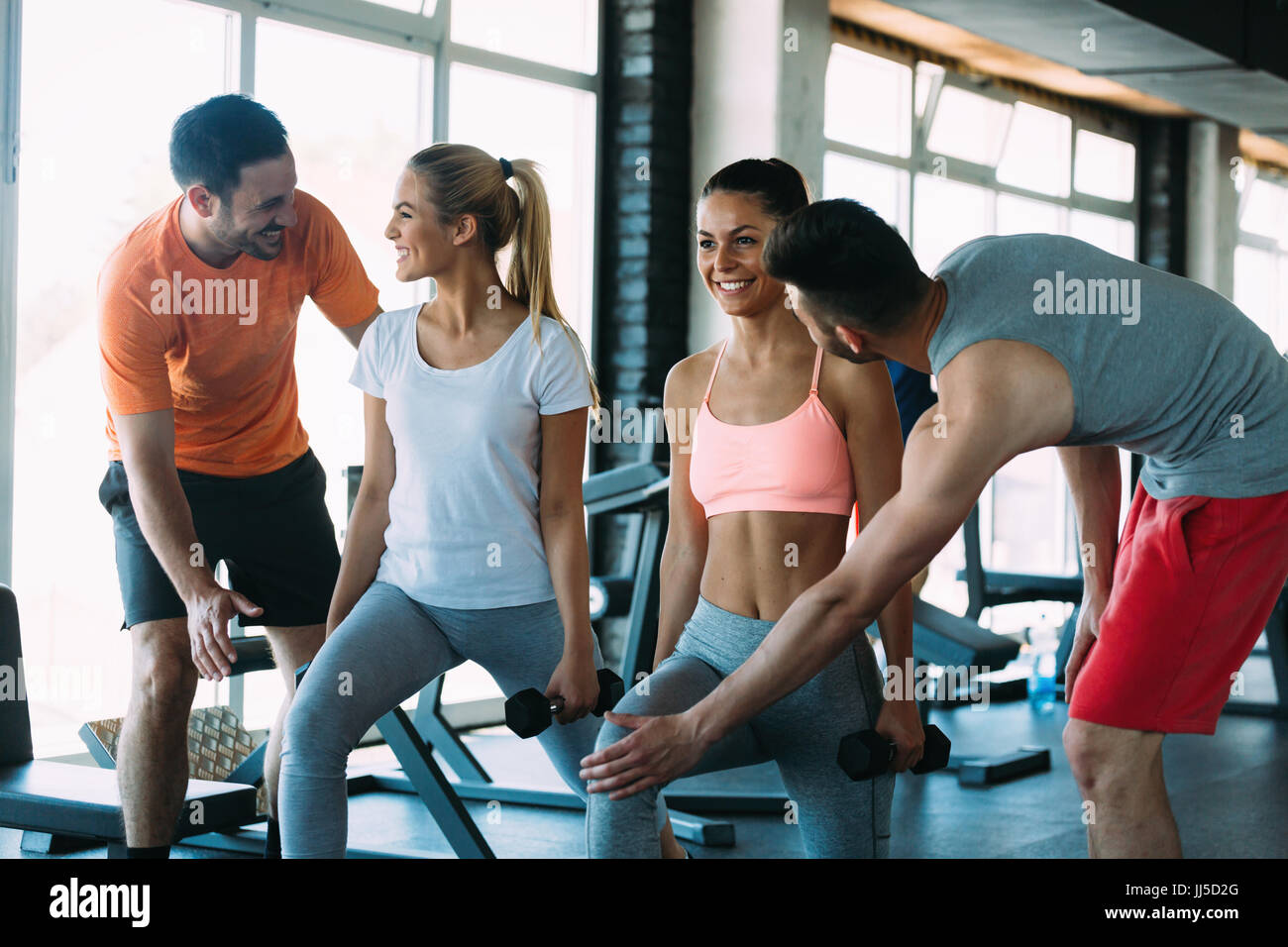 Two attractive women exercising with personal trainers Stock Photo - Alamy