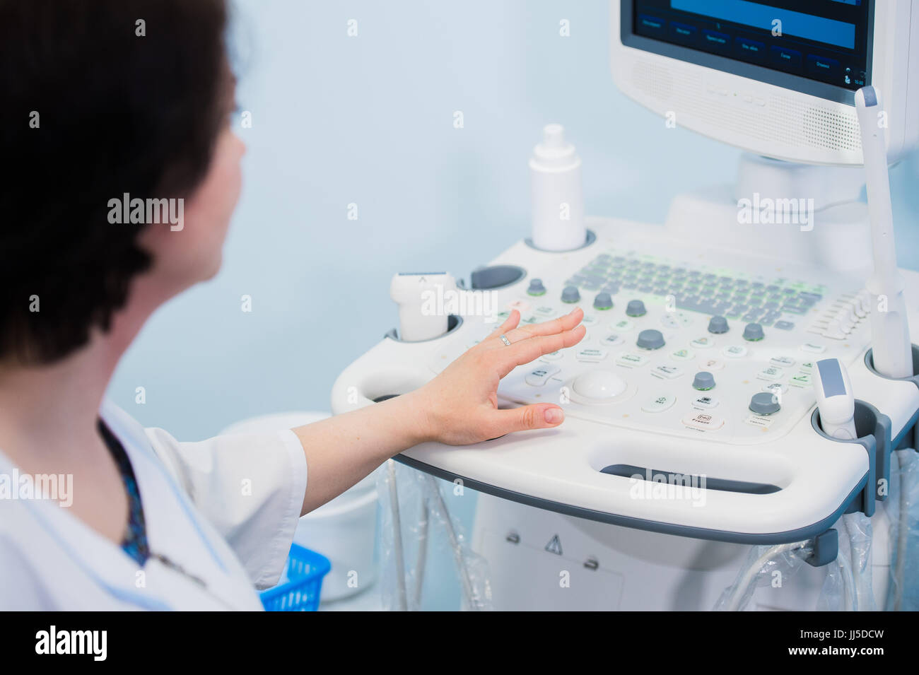 Happy mature female doctor using ultrasound scanner. Echography machine ...