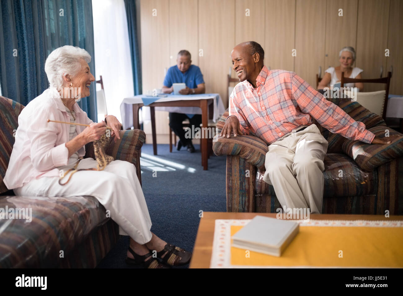 Cheerful senior man talking with woman at retirement home Stock Photo ...