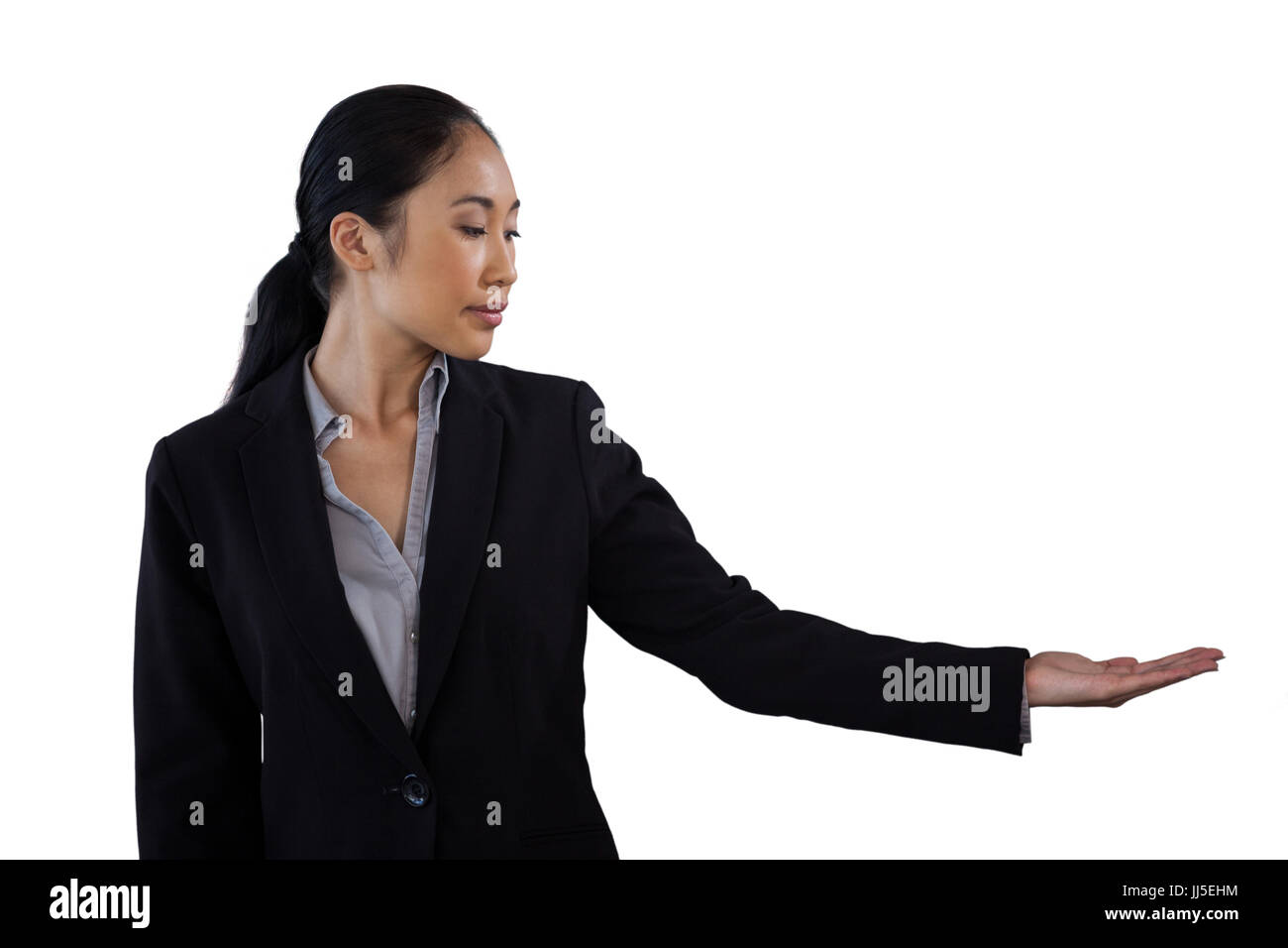 Businesswoman holding invisible product against white background Stock ...