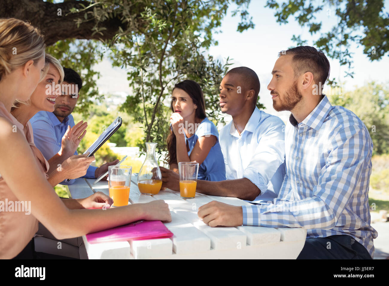 Friends interacting with each other in restaurant Stock Photo - Alamy