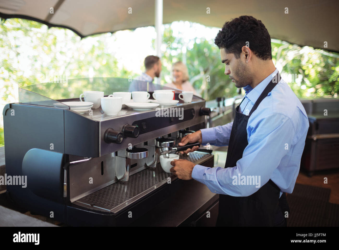 Waiter making cup of coffee from espresso machine in restaurant Stock ...