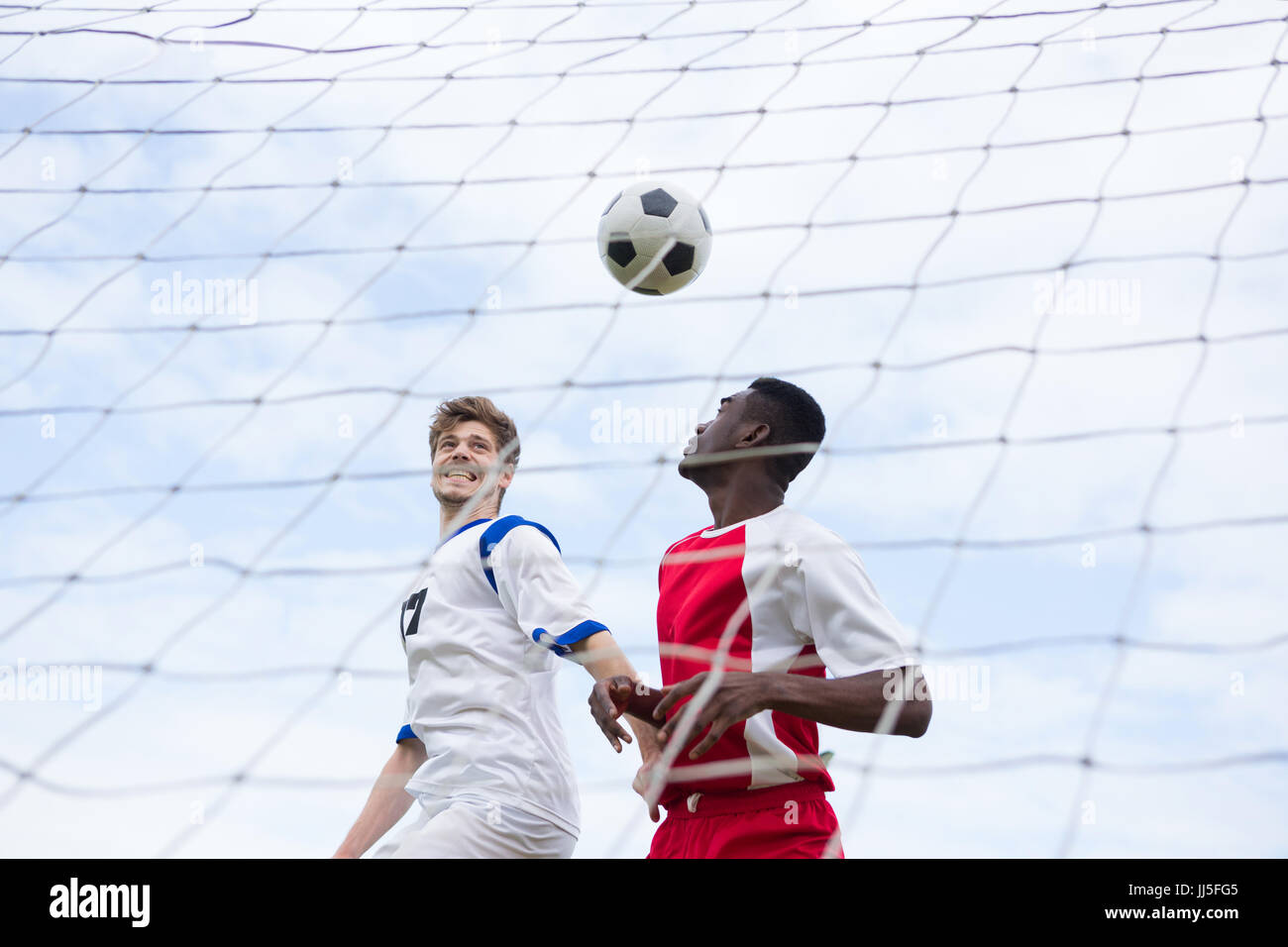 Male player playing soccer against sky Stock Photo - Alamy