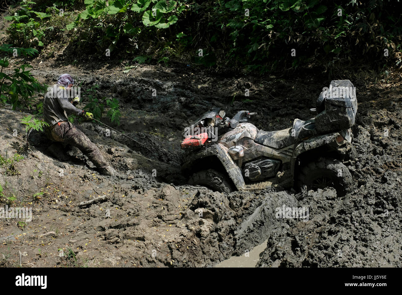 A Russian man pulls out an all-terrain quad bike vehicle ATV stuck in ...