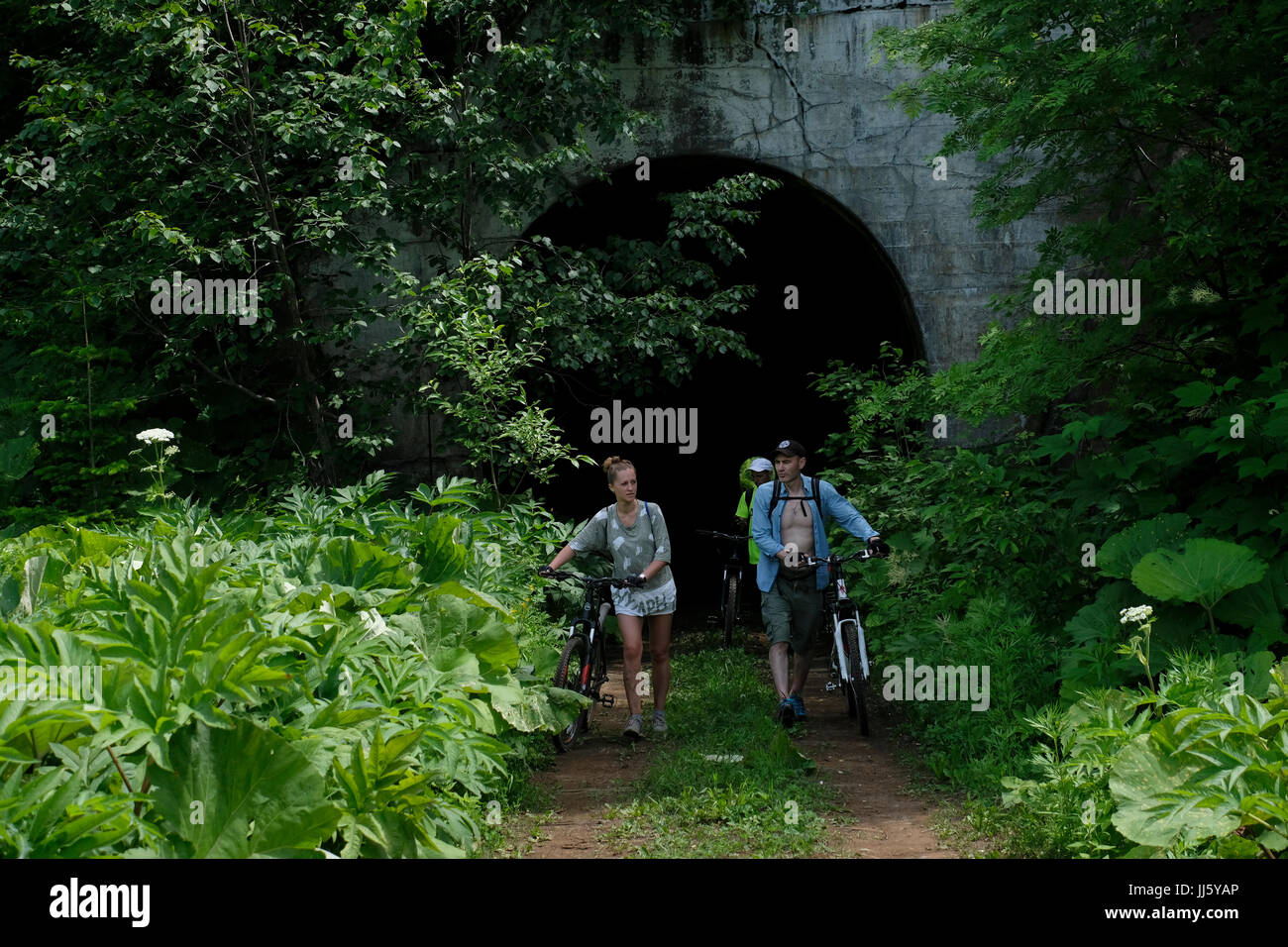 Russian bicyclers hike through an old railroad tunnel of the Kholmsk ...