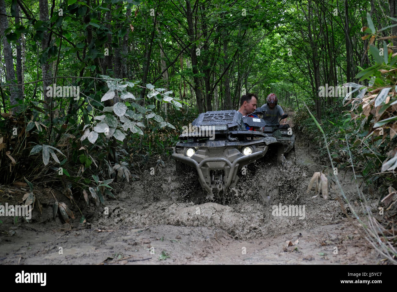 Russian men ride all-terrain quad bike vehicles ATV in a muddy ...