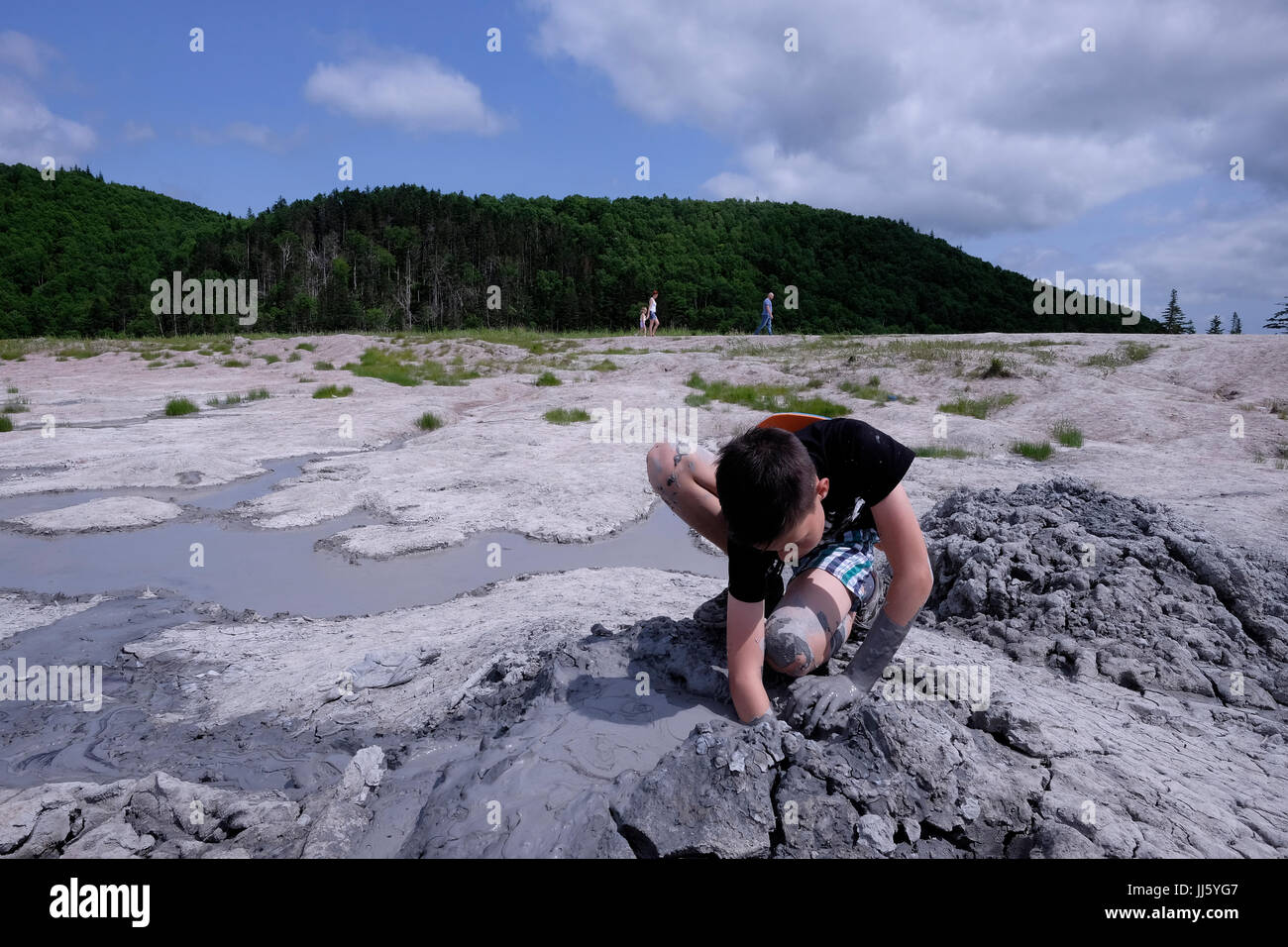 A young Russian boy plays over mud volcano located in the foothills of ...