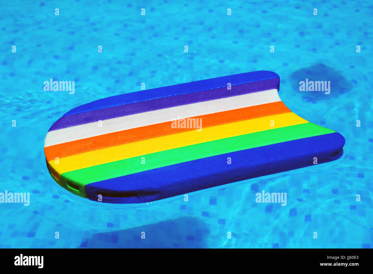 Rainbow pattern styrofoam swimming board or baseboard floating in ...