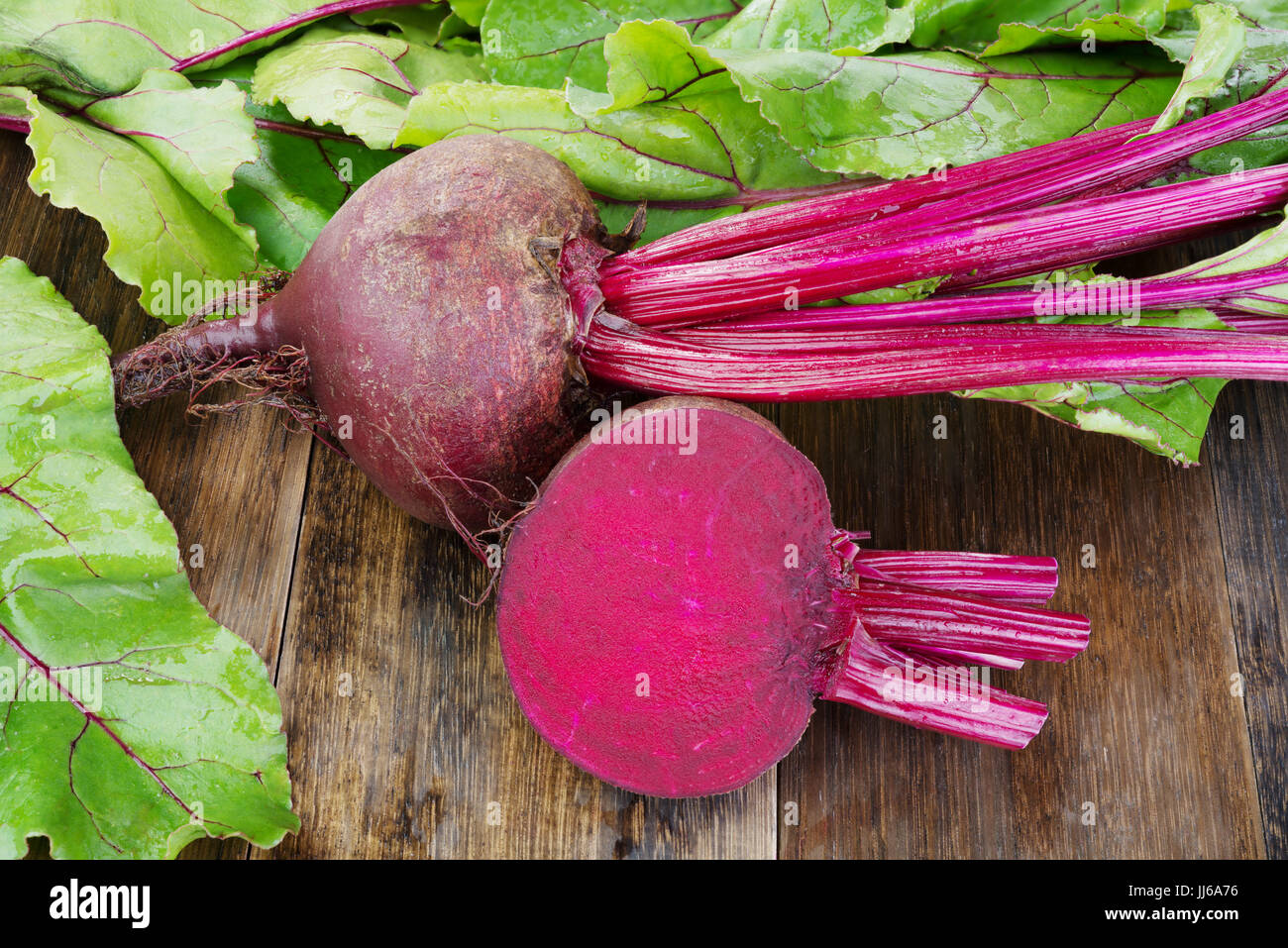 Fresh beetroots with leaves on wooden rustic table.Whole and cut ...