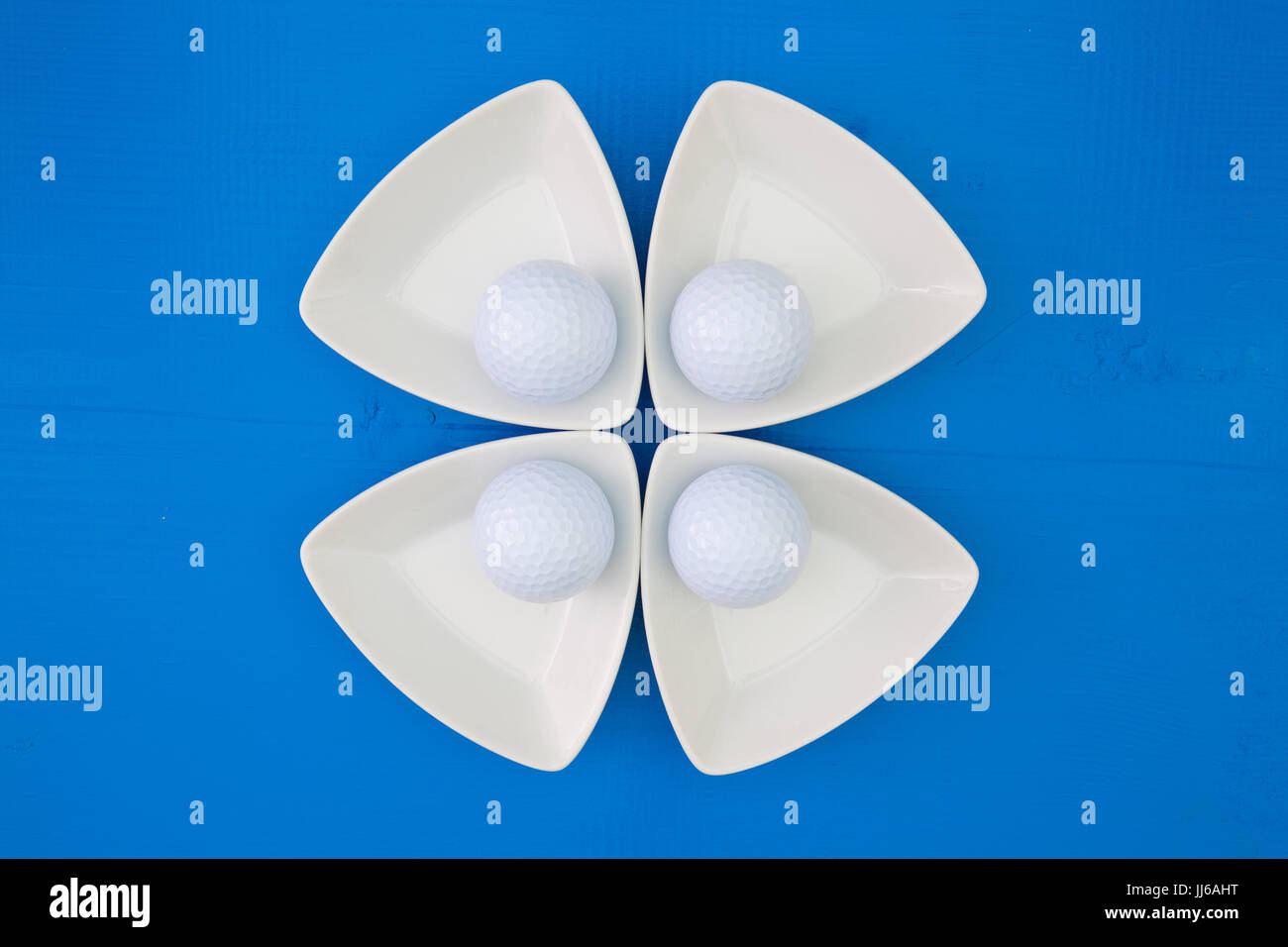 White golf balls on the triangular ceramic bowls for sushi on the blue ...