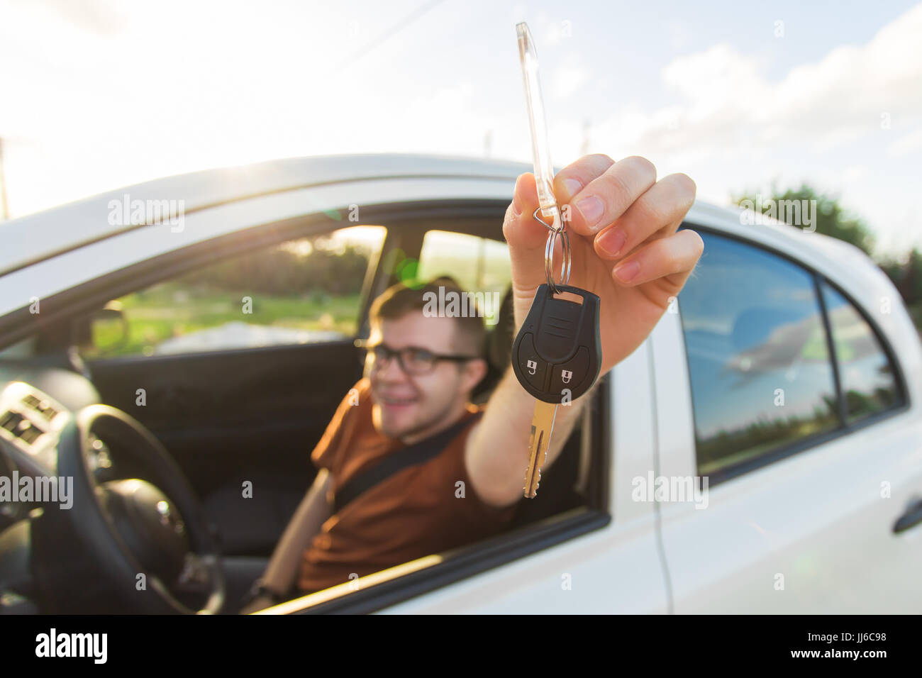 Young driver showing car keys and thumbs up happy. Man holding car key ...