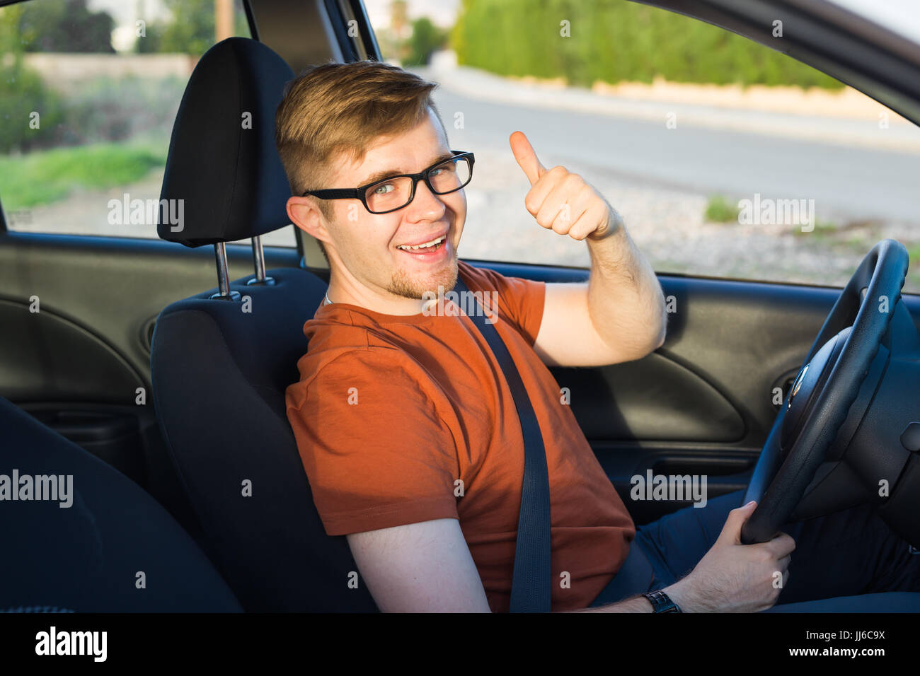 Happy car owner is showing thumbs up inside his new car Stock Photo - Alamy