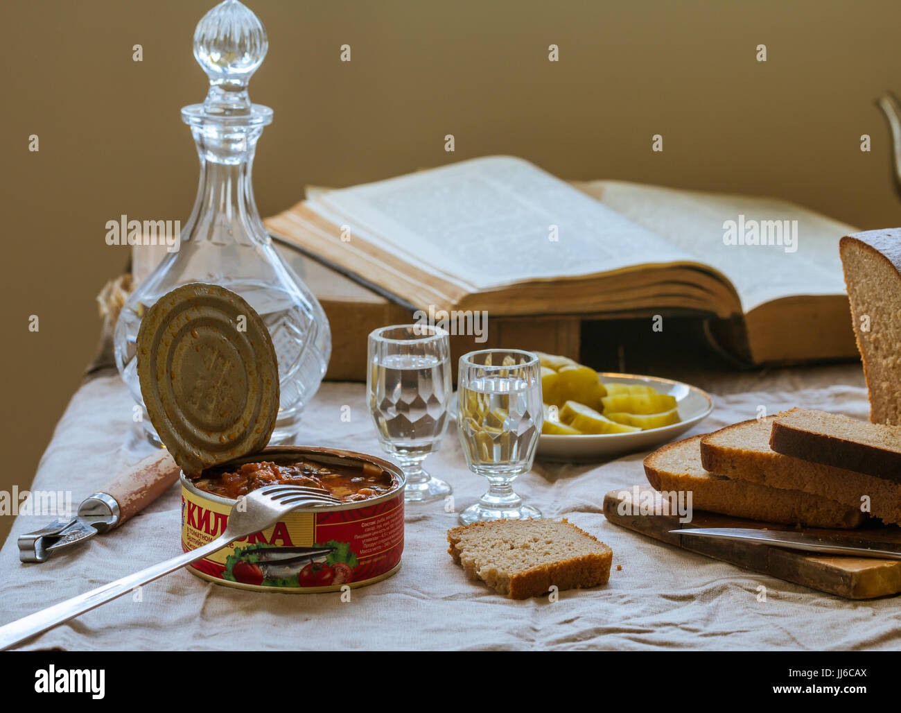 Tin can of fish sprat in tomato sauce with rye bread and vodka on ...