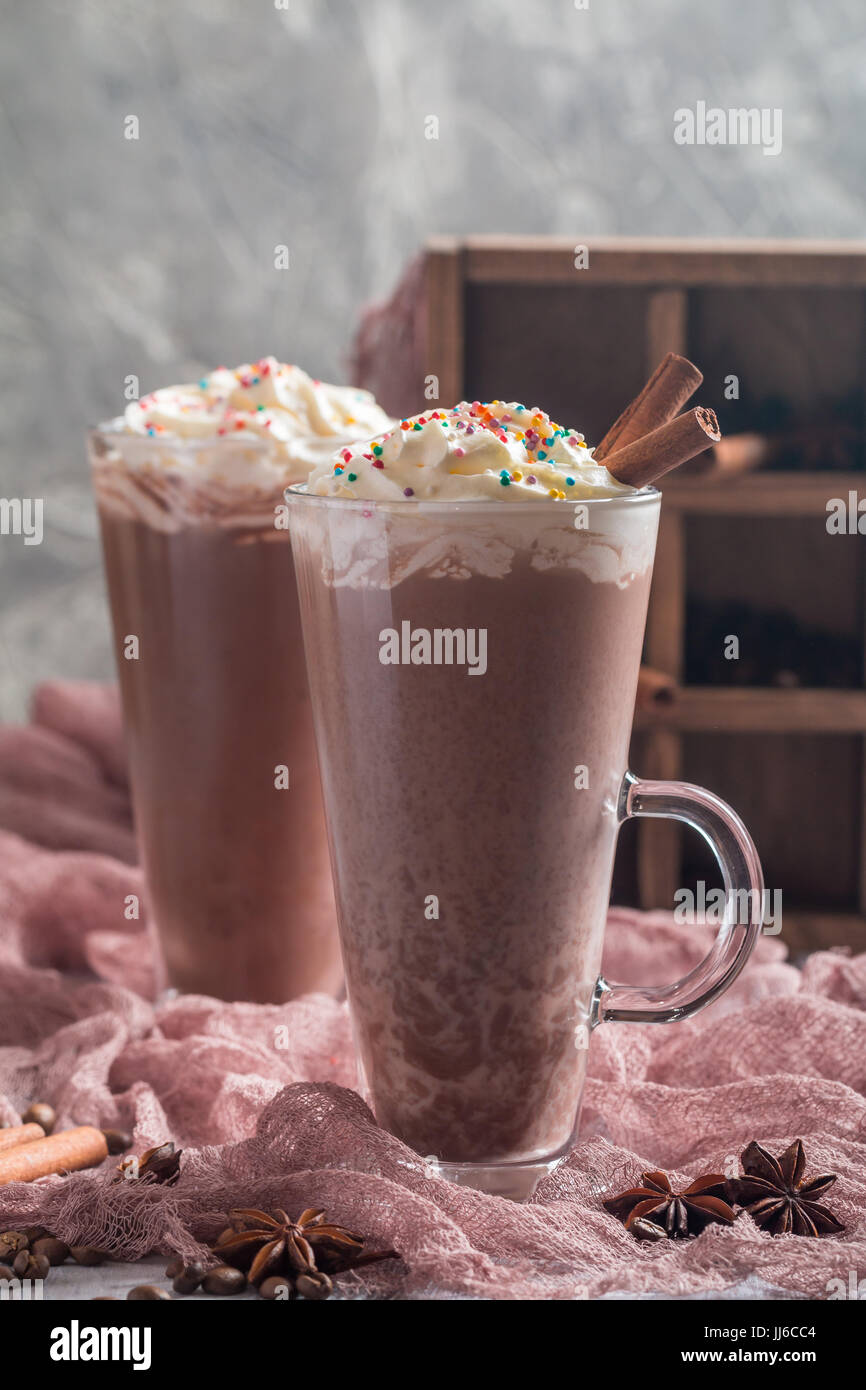 Chocolate milkshake in tall glass mugs with whipped cream on wooden ...